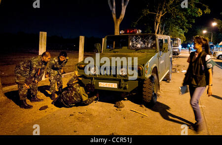 Thai soldiers fix flat tire on their damaged Humvee which park inside ...