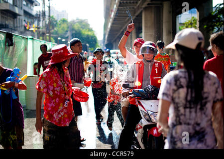 Red Shirts splash passing by motorist with water during the Songkran ...