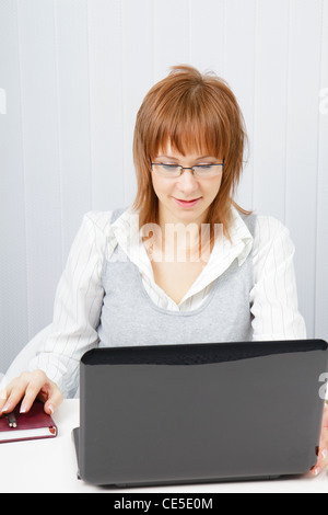 tired worker in the office. Disheveled girl with laptop. neck pain ...