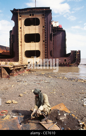 Indian man gas cutting steel plate in Alang ship breaking scrap yard Gujarat India Asia Indian ...