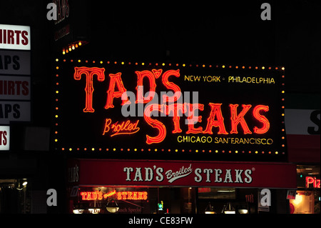 Night view shop selling T-shirts, red neon Tad's Steakhouse, Sbarro ...