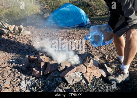 Dousing the camp fire Stock Photo - Alamy
