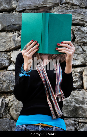 young woman standing reading book at meadows Stock Photo - Alamy