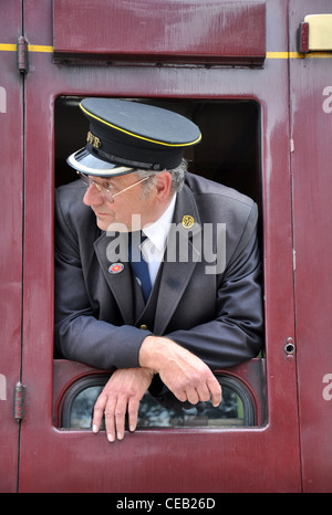 Steam train conductor leaning out of passenger car window Stock Photo ...