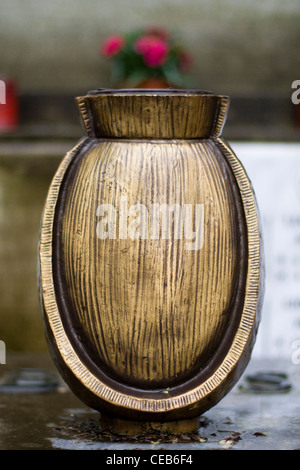 Funerary urn with ashes of dead and flowers at funeral. Burial urn ...