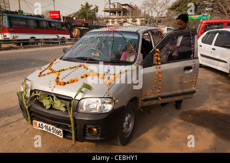 A Maruti Suzuki car is decorated with flowers and banana leaves for the ...