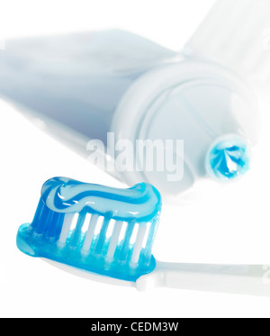 A tube of toothpaste, white and blue striped toothpaste on an orange ...