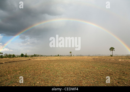 Rainbow over field Stock Photo - Alamy