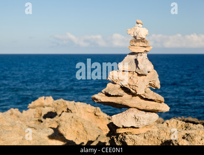 Pyramid shaped stack of rocks balanced on the edge of ocean Stock Photo ...