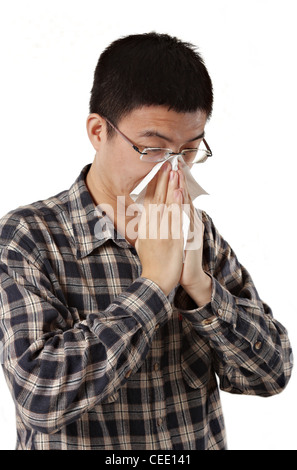 Asian man blowing nose on sofa at home for cold and flu relief Stock ...