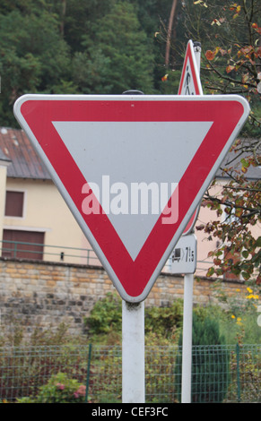 A blank inverted triangle road sign (meaning "Yield") in Bourglinster ...