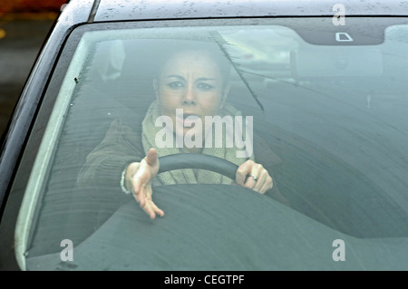 Female in her 20s angry driving a car with road rage shouting at other ...