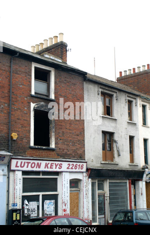 boarded up shop with fire damage Stock Photo - Alamy