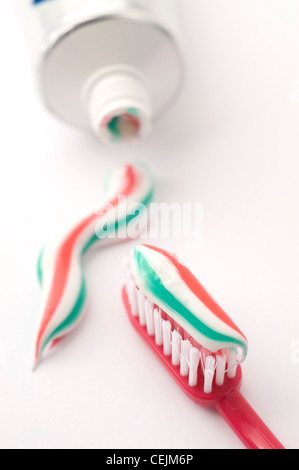 A tube of toothpaste, with white, green and red striped toothpaste on a ...
