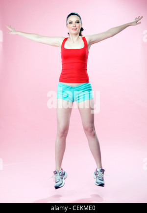 A female doing a star jump in the middle of a meadow Stock Photo - Alamy