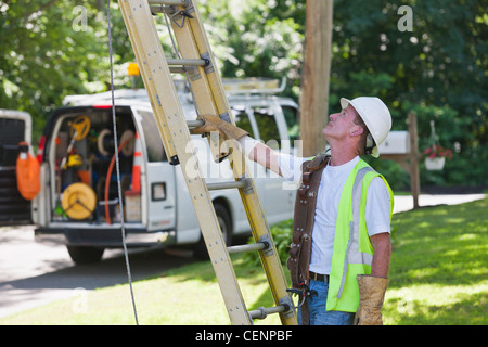 Cable lineman climbing up a ladder on city power pole Stock Photo - Alamy