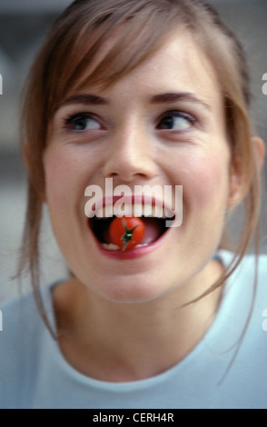 Female biting into cherry tomato Stock Photo - Alamy