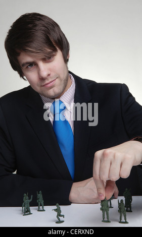 business man playing with toy soldiers Stock Photo - Alamy