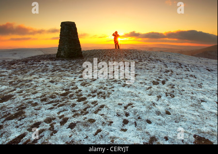 A lone hiker watches the sunset from the top of Mam Tor in Derbyshires ...