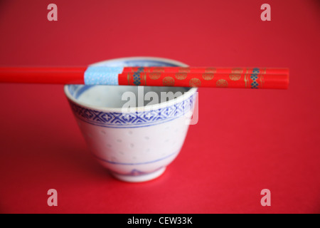 Red wooden chopsticks resting across china cup Stock Photo - Alamy