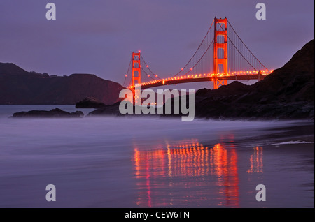 Golden gate bridge view from beach. Cloudy sky in background, waves in ...