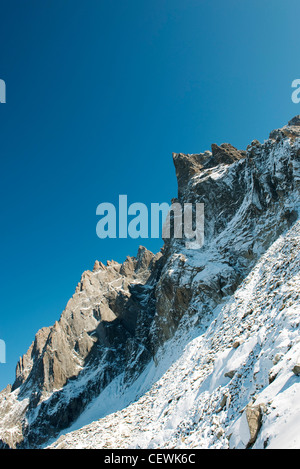 A scenic shot of snowy mountains covered with clouds under the sunlight ...