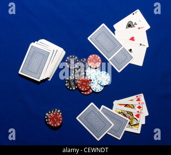 Poker hand layed out on blue background with two hidden cards and chips ...