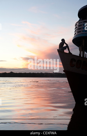 Silhouette man sitting in a boat fishing at sunset Stock Photo - Alamy