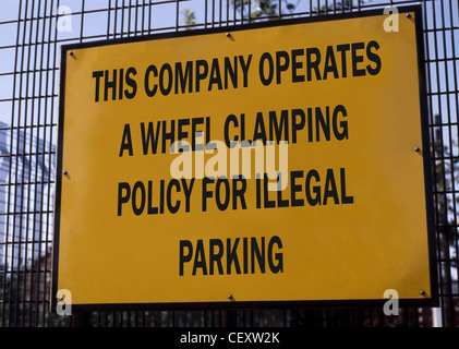 no unauthorised parking wheel clamp in operation release fee sign on a ...
