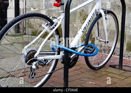 Expensive bicycle secured to a metal post with heavy duty chain and ...
