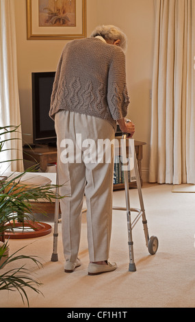 Elderly lady using a wheeled walking frame Stock Photo - Alamy