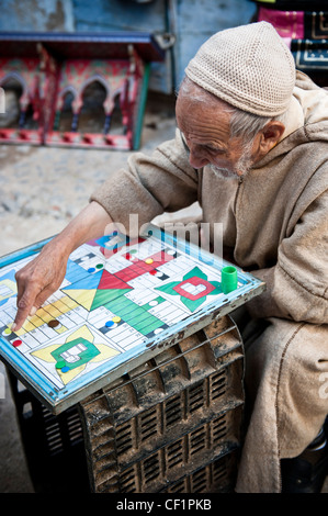 Moroccan people playing street games in Place Djemaa El Fna, the famous ...