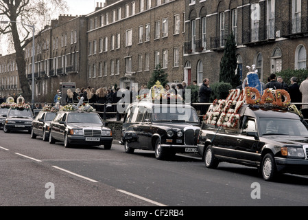 Procession of funeral cars laden with flowers on the roof follow the ...