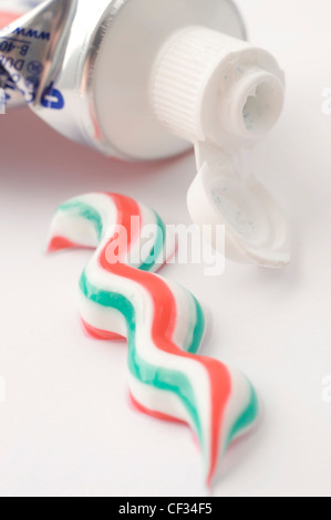 A tube of toothpaste, with white, green and red striped toothpaste on a ...