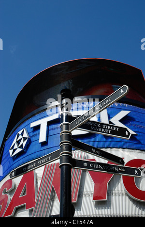 Looking up at pedestrian signposts and the giant advertisements of ...