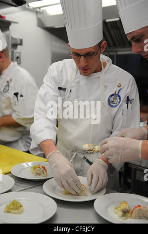 The Coast Guard Culinary Arts Team uses a ships wheel to display some ...