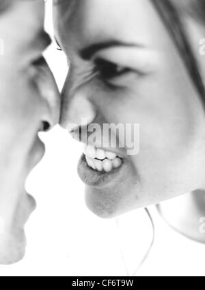 Couple arguing face to face pushing noses against each other shouting ...