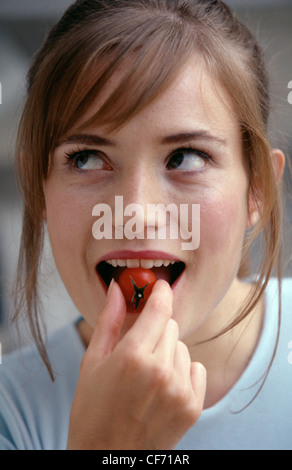 Female biting into cherry tomato Stock Photo - Alamy