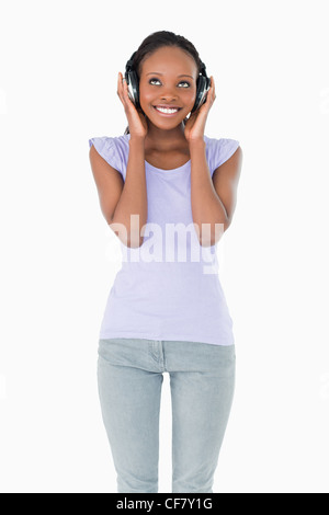 Happy Black woman enjoying music with headphones and smartphone ...