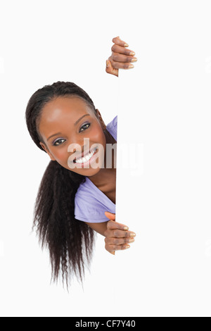 Young woman looking around the corner on white background 2 Stock Photo ...