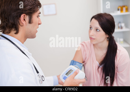 Young woman getting blood pressure taken, low angle view Stock Photo ...