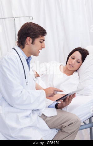 Male doctor with tablet and patient on light background Stock Photo - Alamy