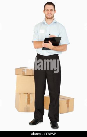 Smiling young post employee with parcels and document folder isolated ...