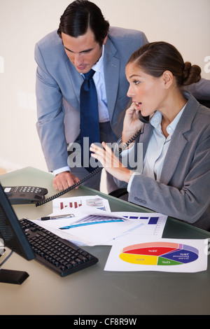 Businesswoman getting a phone call while analyzing statistics Stock ...