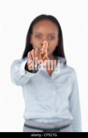 Portrait of a young businesswoman touching an invisible screen against ...