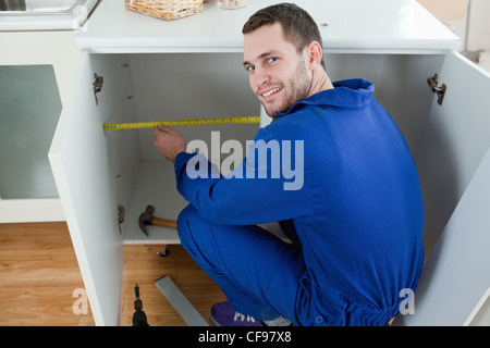 Smiling repair man measuring something Stock Photo - Alamy