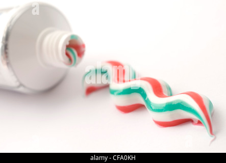 A tube of toothpaste, with white, green and red striped toothpaste on a ...