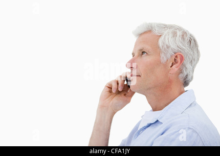 Side view of a man making a phone call while looking at the camera ...