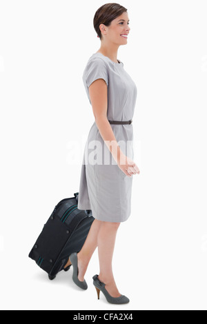 Side view of woman with bag standing on city street during sunny day ...