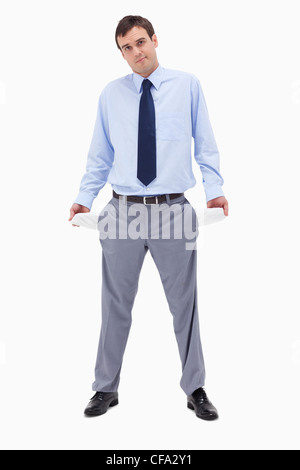 Broke businessman showing his empty pockets against a white background ...